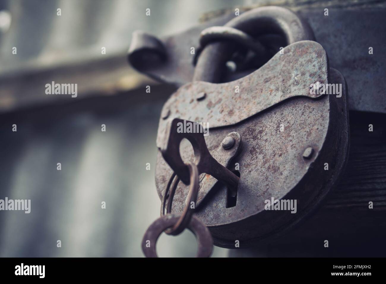 Iron rusty lock with a key. Closed door. Locked gates to the barn lock ...
