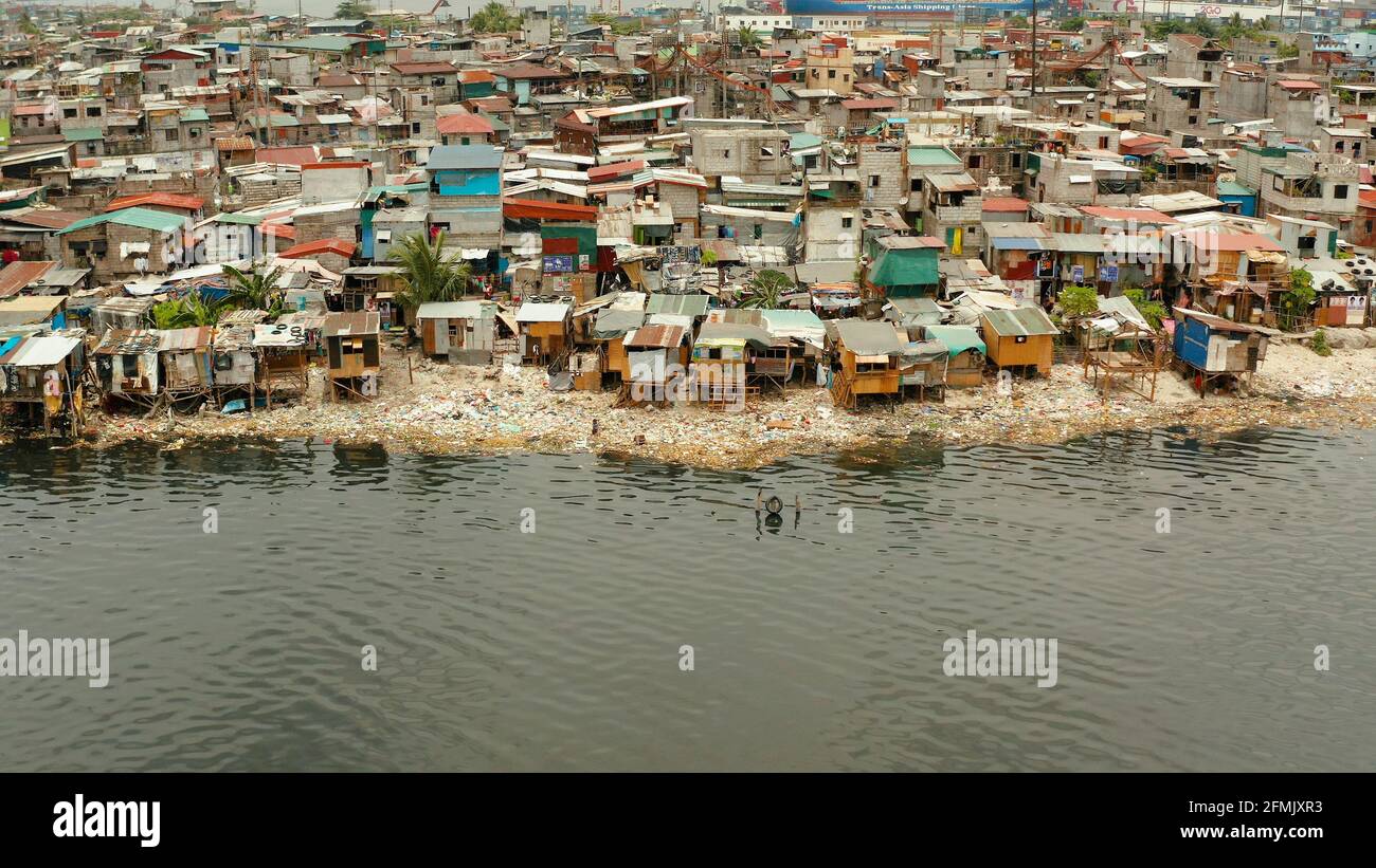 Slums with shacks of local residents and the river bank littered with ...