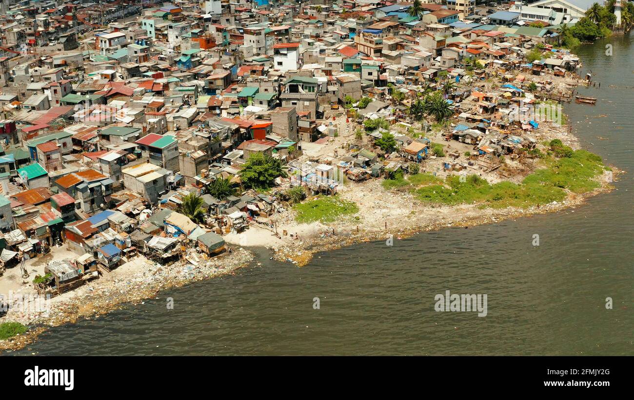 Slums in Manila near the port. River polluted with plastic and garbage ...