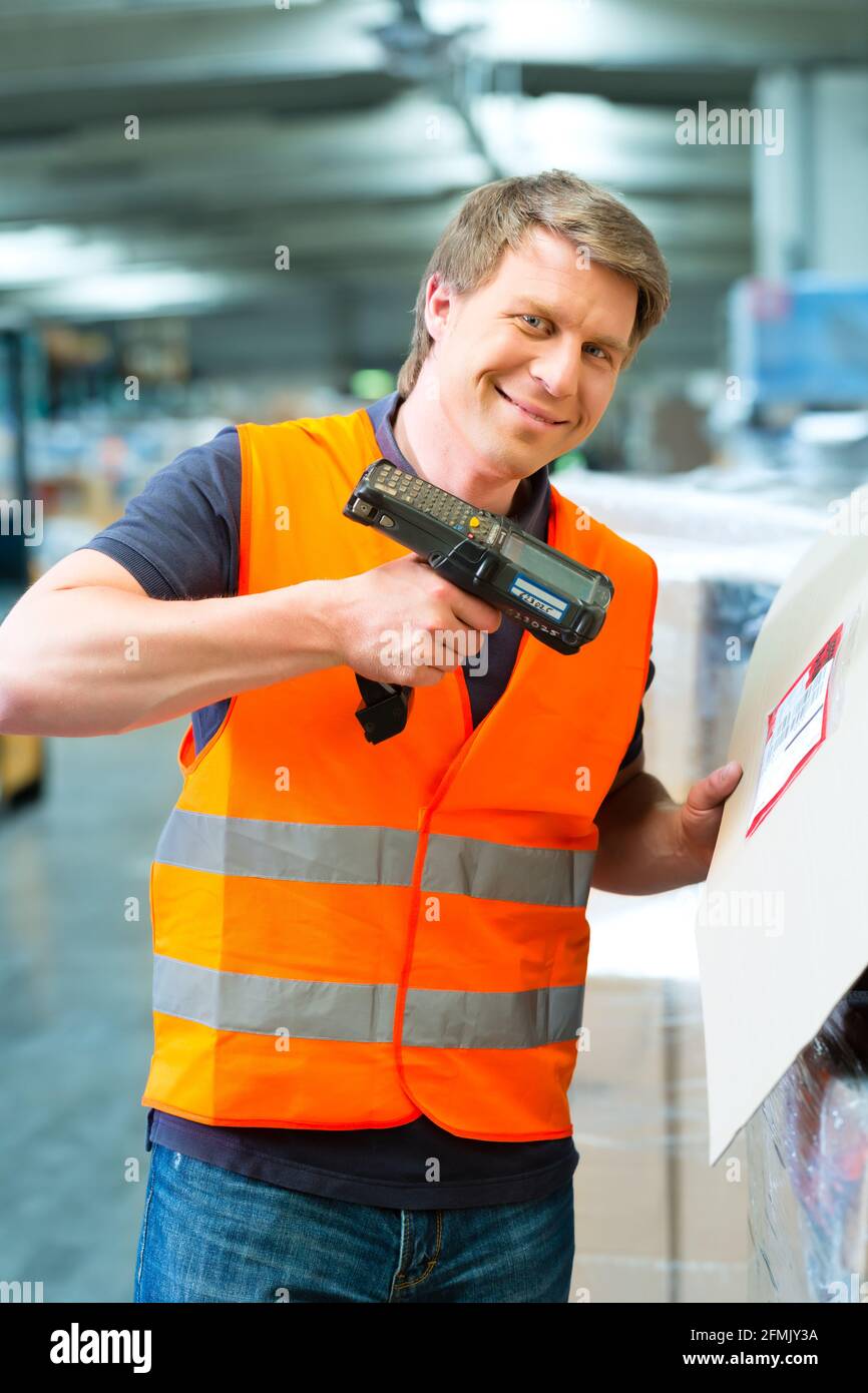 Logistics - Warehouseman with protective vest and scanner, scans bar ...