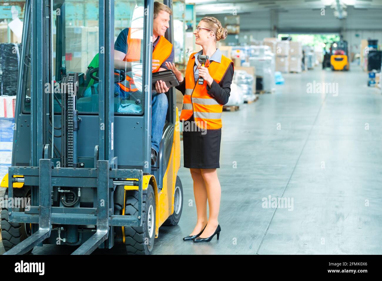 Logistics Teamwork - forklift driver, Worker or warehouseman and his ...