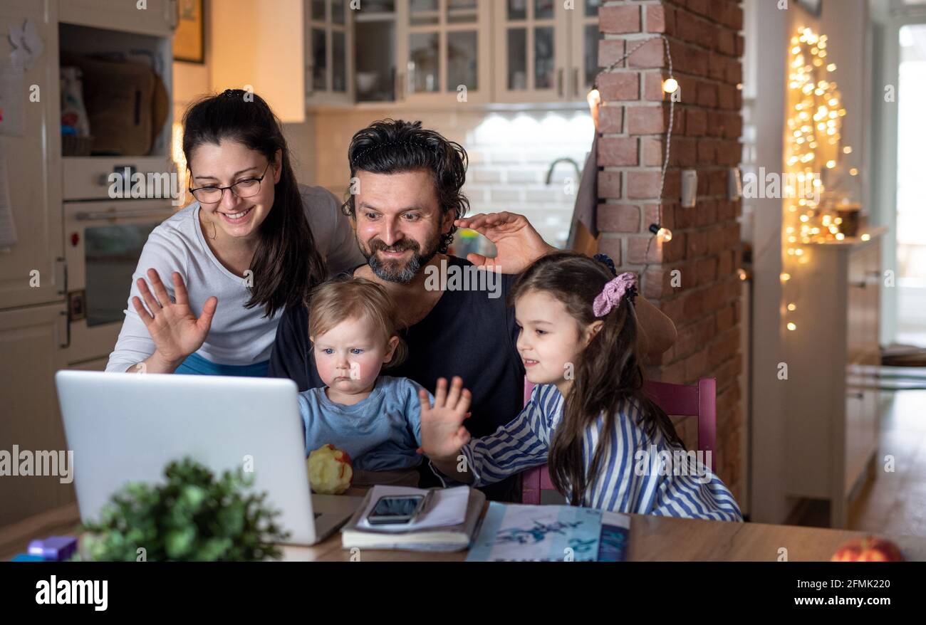 Family with small daughters in kitchen, distance learning, video call ...
