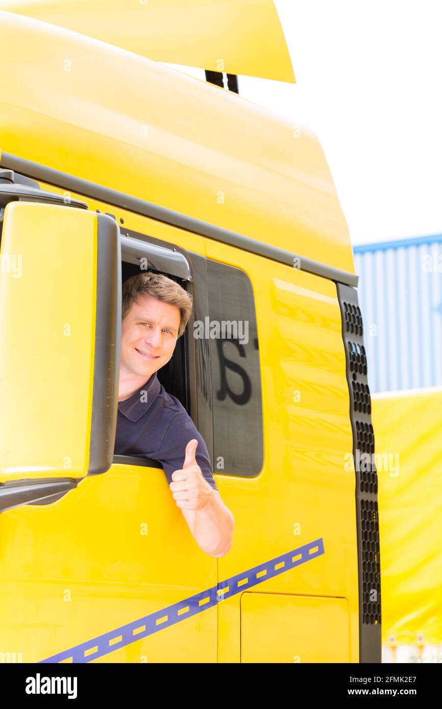 Logistics - proud driver or forwarder in drivers cap of truck and ...