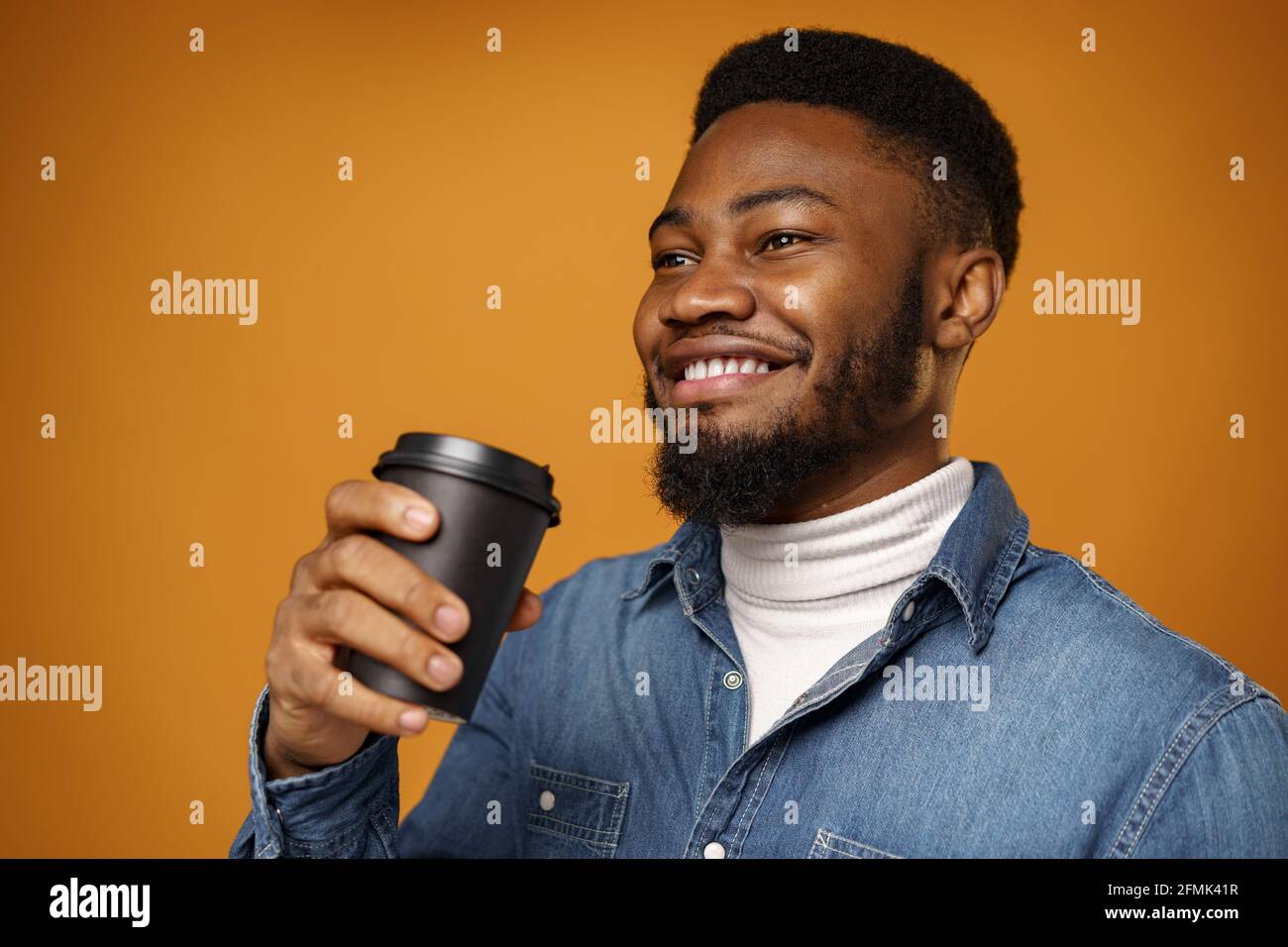 Young african american guy enjoying his takeaway cup of coffee against ...