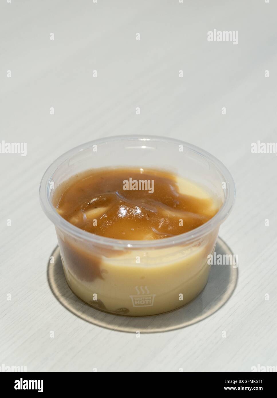 Closeup of hot mashed potatoes with gravy in a plastic container ...