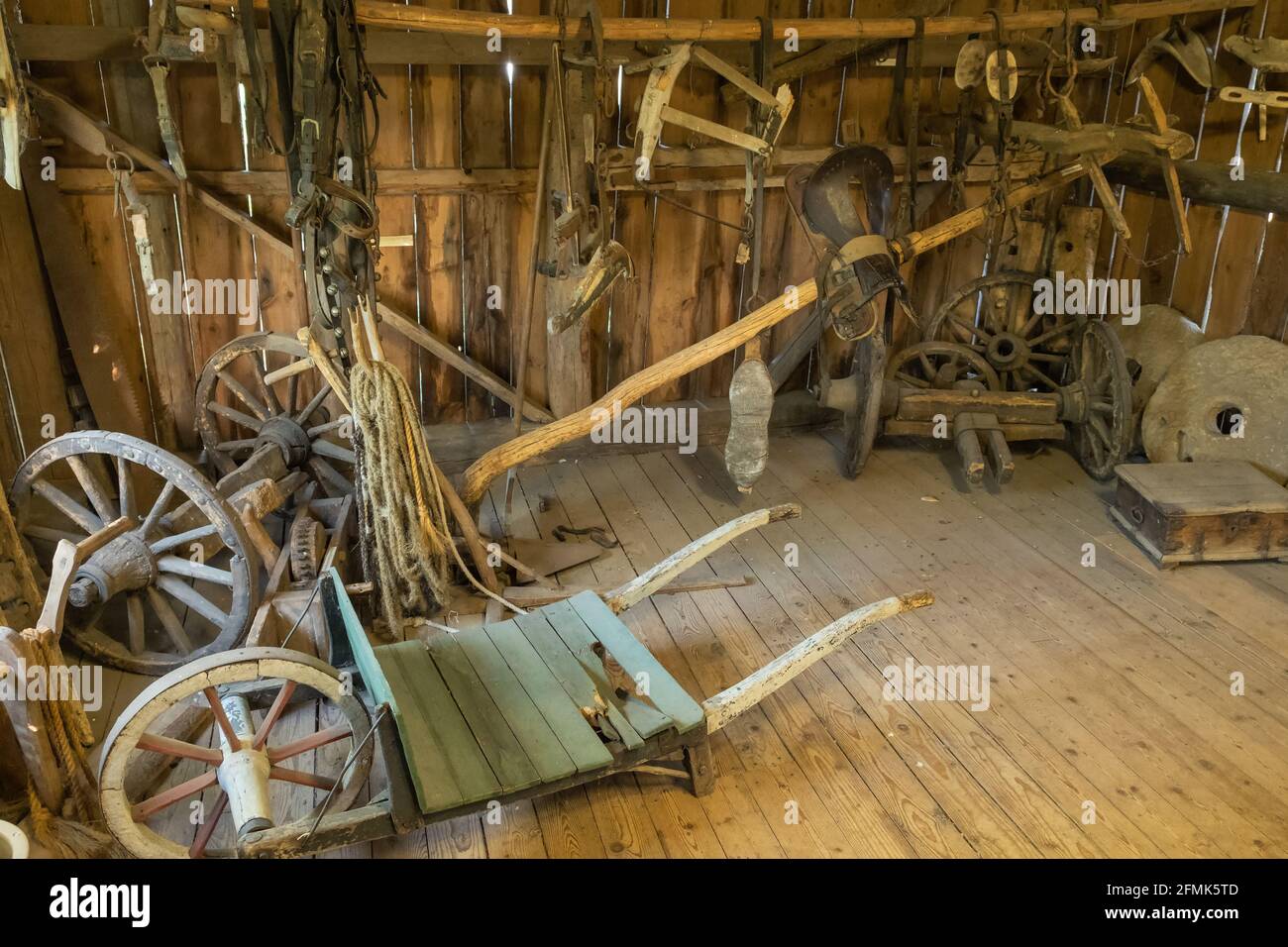 Old wheelbarrow and other agricultural implements in a barn Stock Photo ...