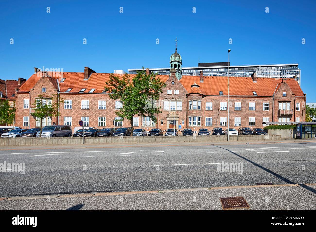 a red hospital building by busy road in denmark Stock Photo - Alamy