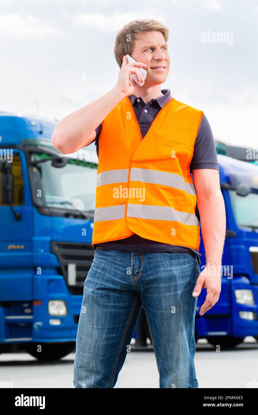 Logistics - proud driver or forwarder with mobile phone in front of ...