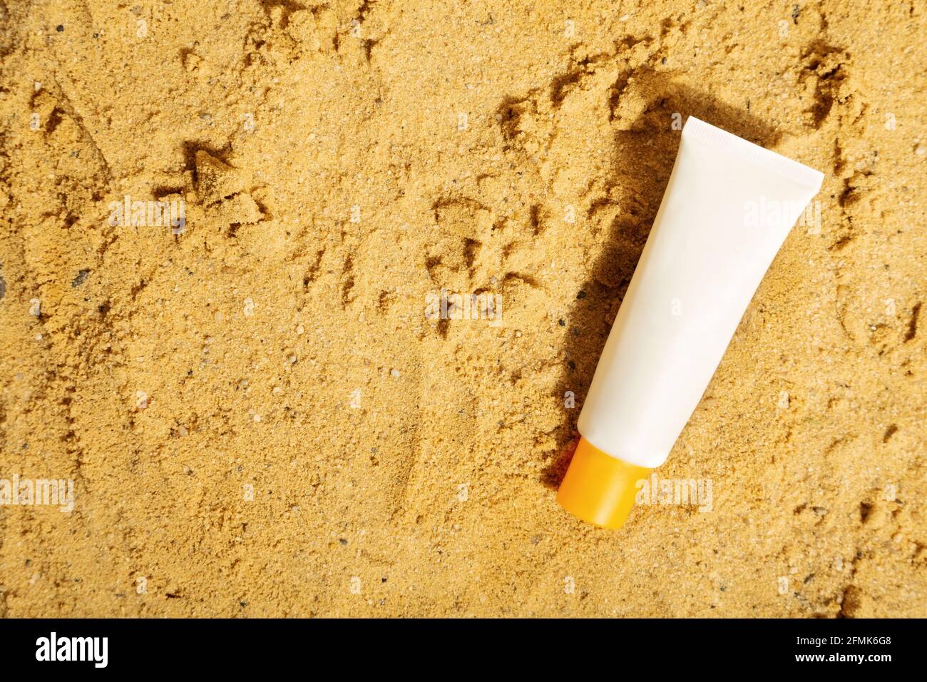 White tube of sunscreen on beach sand. Sun Protection. Top view. Copy ...