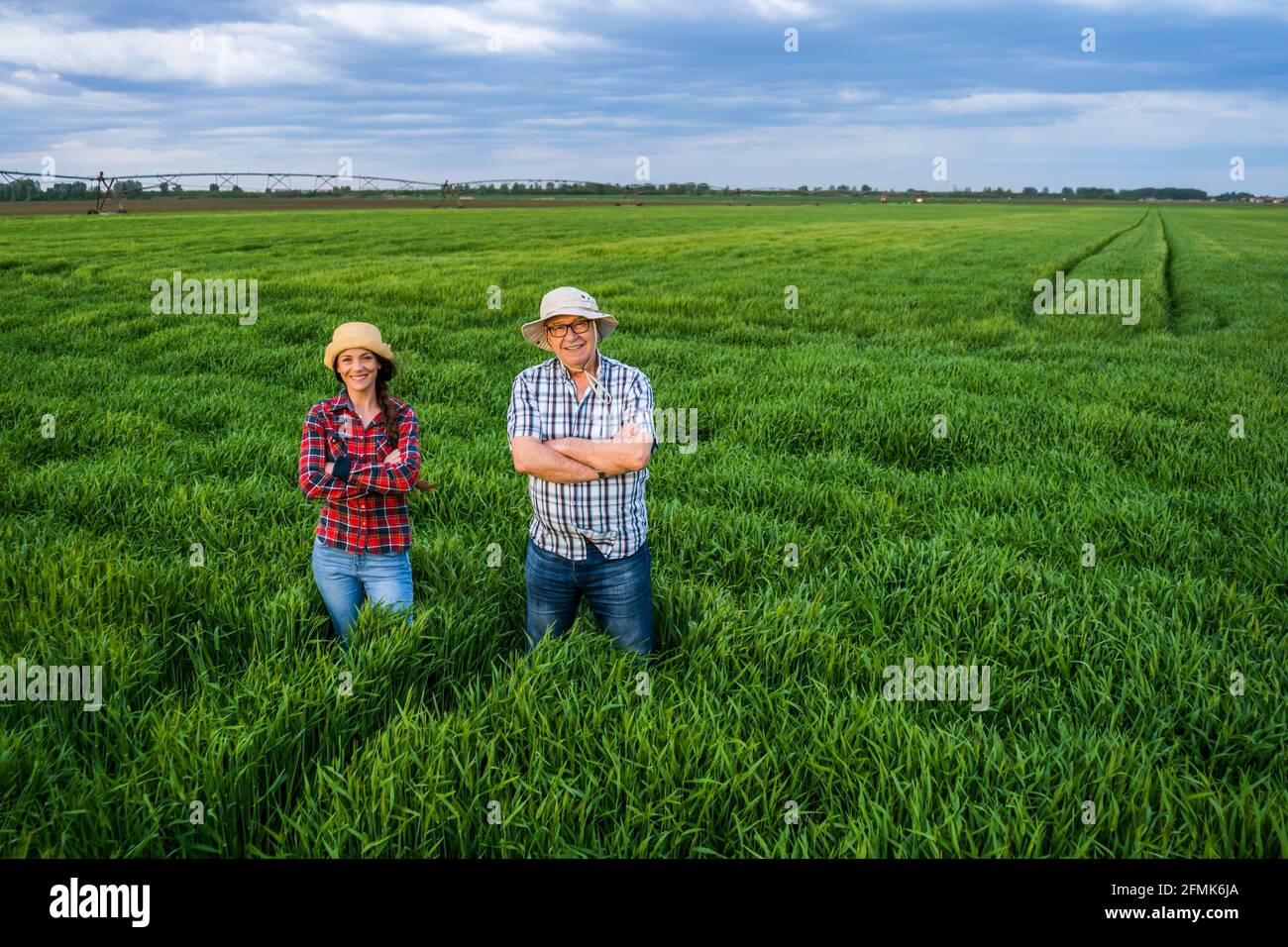 Proud two generations farmers are standing in their barley field in ...