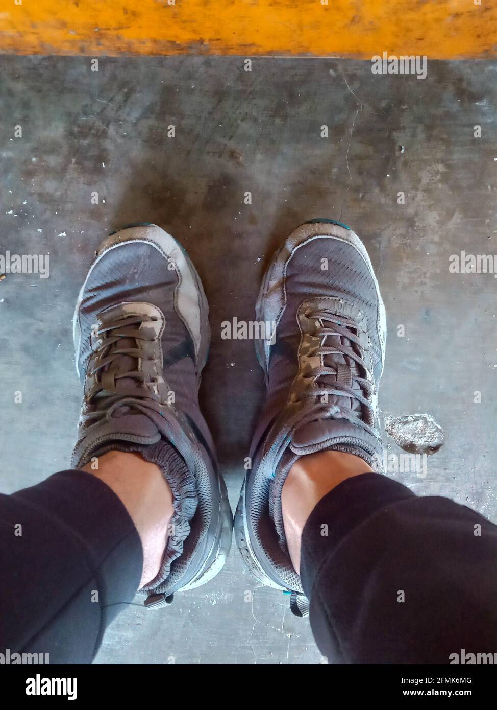 a color photo of a pair of feet wearing worn shoes in the morning Stock ...