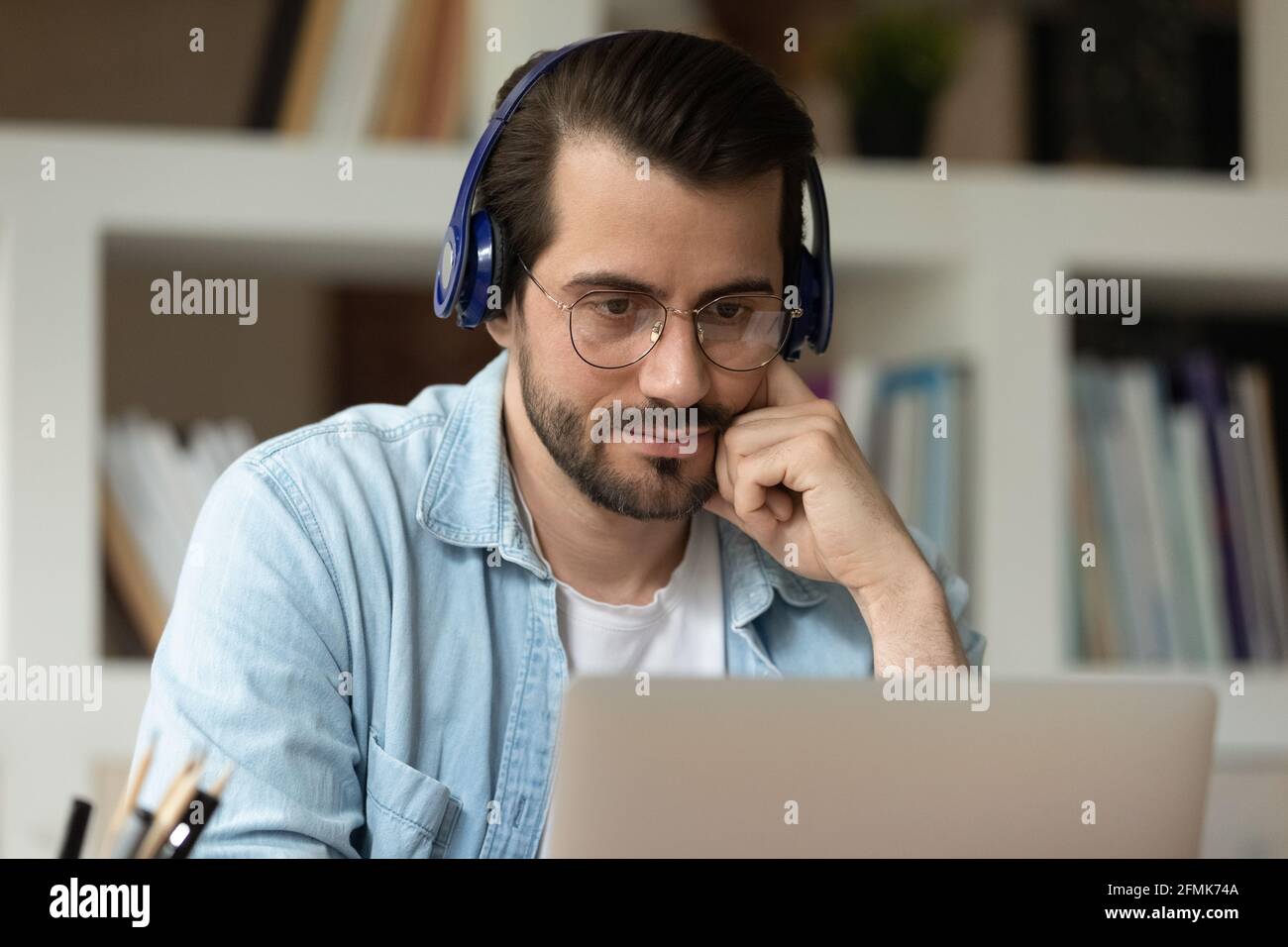 Close up focused man in glasses and headphones using laptop Stock Photo ...