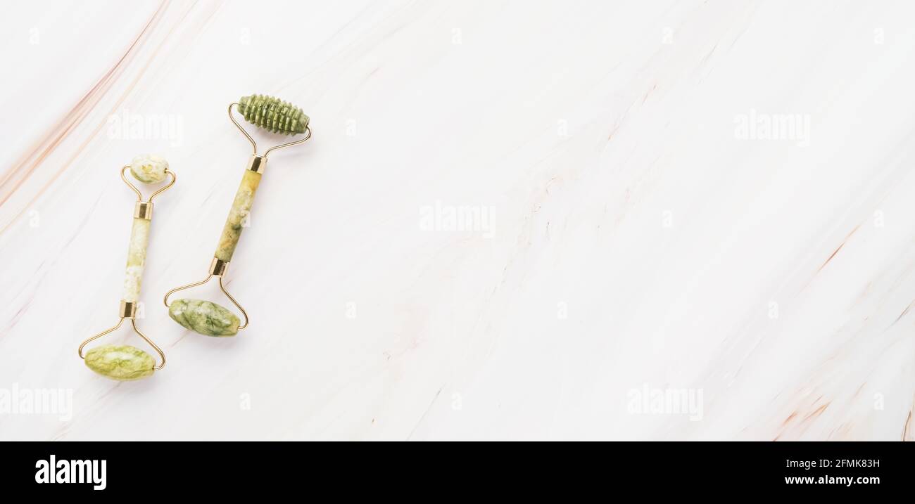 SPA concept. Two green face rollers from natural jade stone on a light ...
