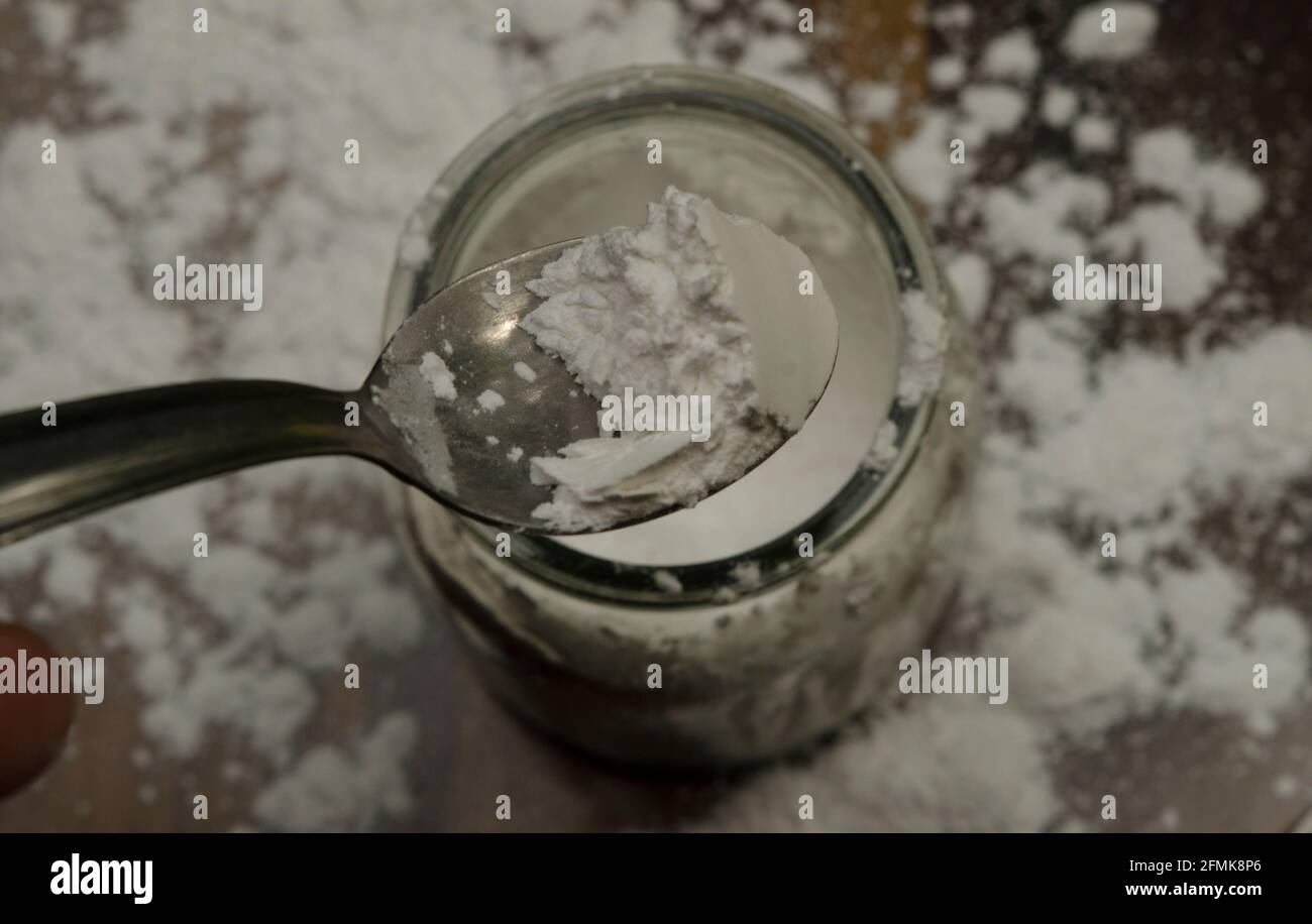 baking powder in spoon on wood. Taken out of a jar, or it can be baking ...