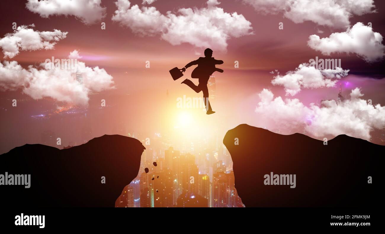 Businessman jumping through the gap between hills. Man jumping over ...