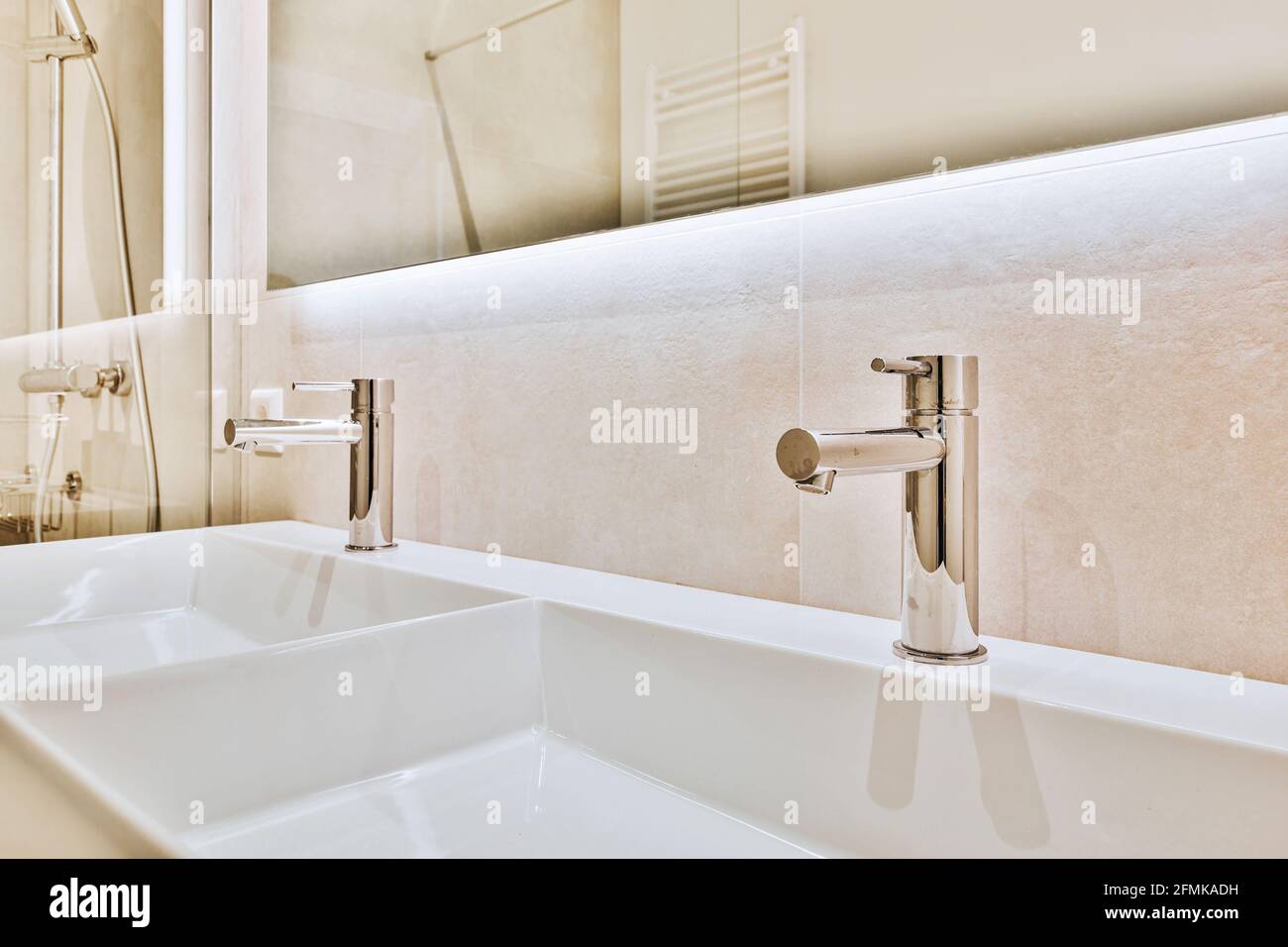 Shiny taps over sinks in bathroom Stock Photo - Alamy