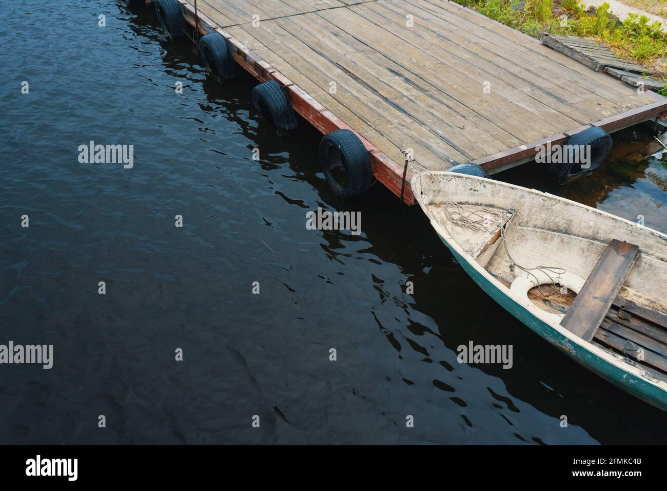 Old fishing boat parked near wooden pier Stock Photo - Alamy