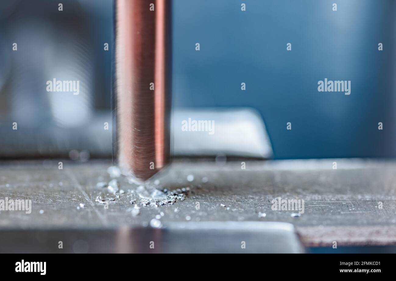 Drilling process with shavings close-up at the workplace in workshop ...