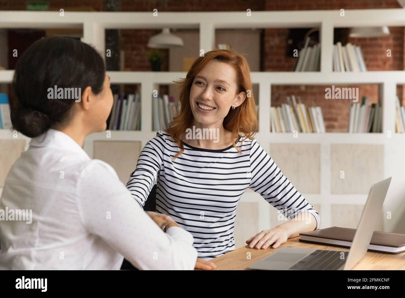 Two businesswomen shaking hands in an office hi-res stock photography ...