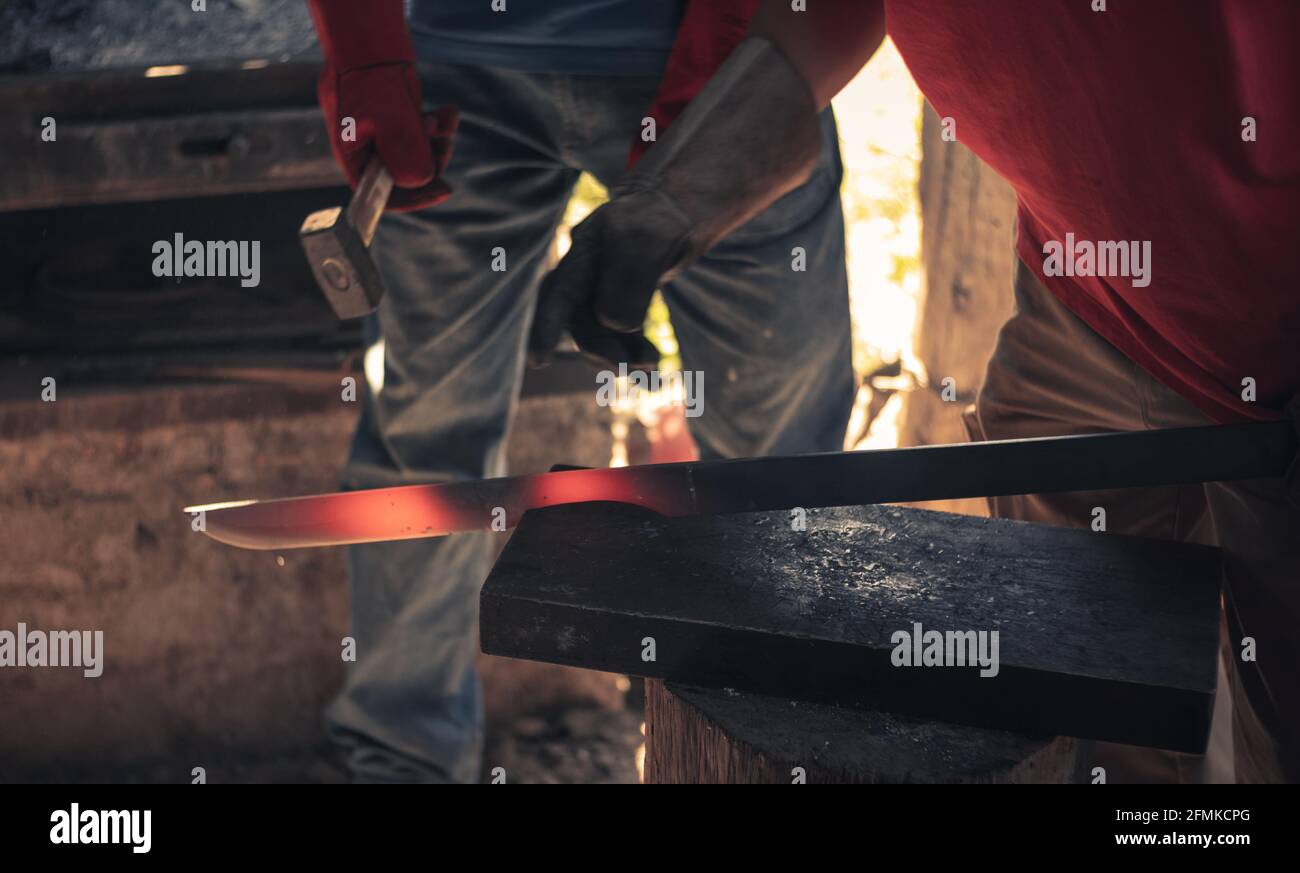 Tapping hot metal with a hammer on an anvil Stock Photo - Alamy