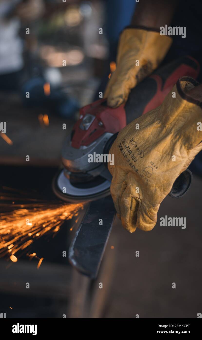Working in a piece of iron with a grinding machine Stock Photo - Alamy