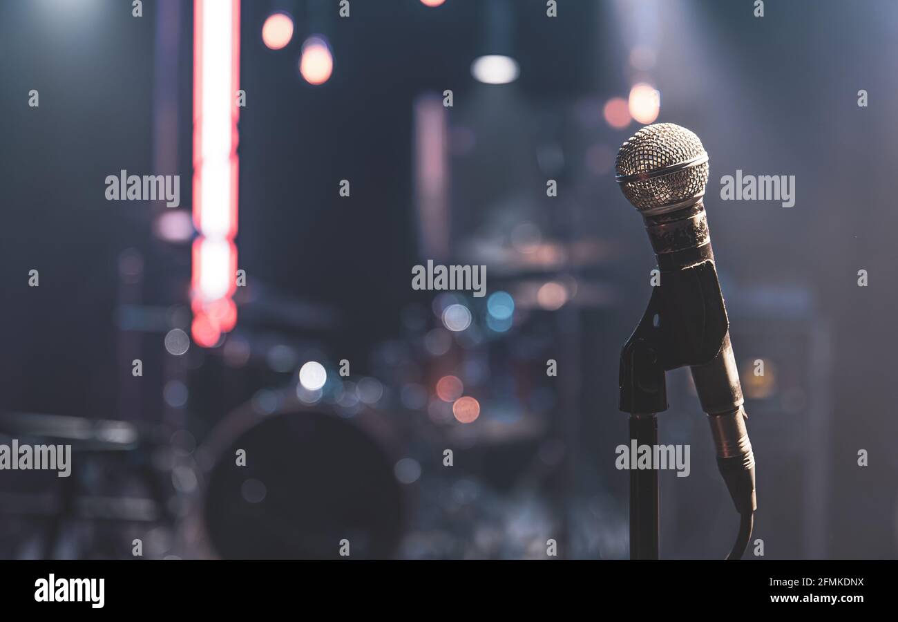 Close up of a microphone on a concert stage with beautiful lighting ...