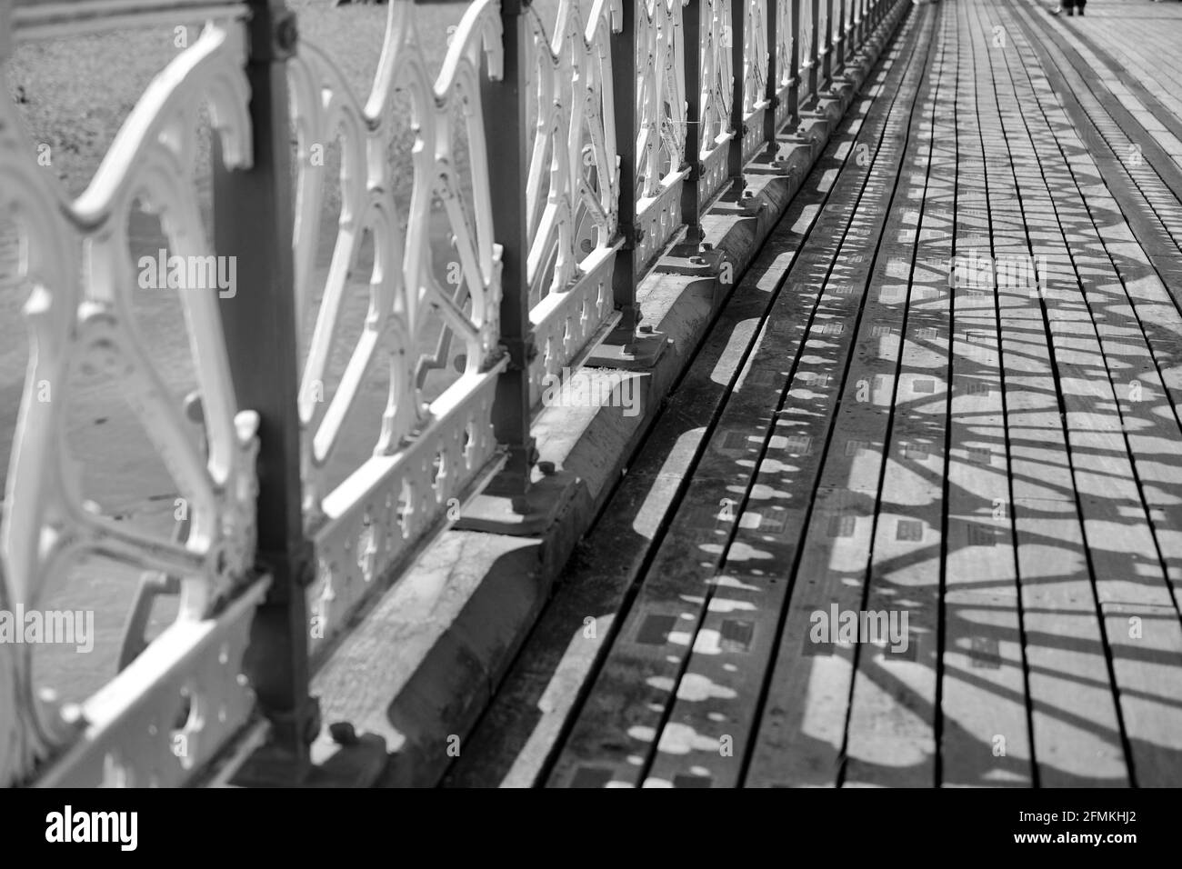 Monochrome photo old Victorian pier and promenade. The sunlight streams ...