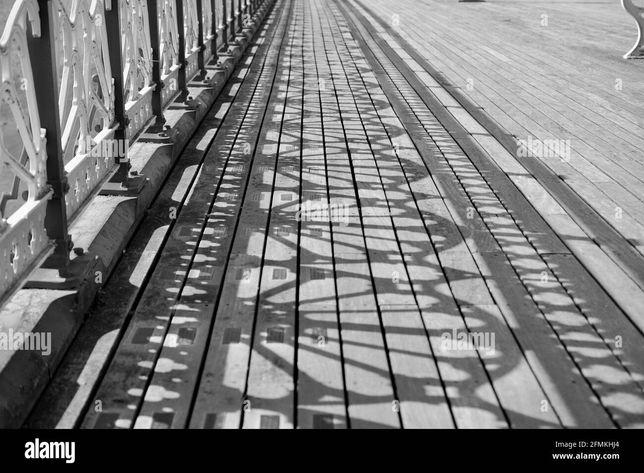 Monochrome photo old Victorian pier and promenade. The sunlight streams ...