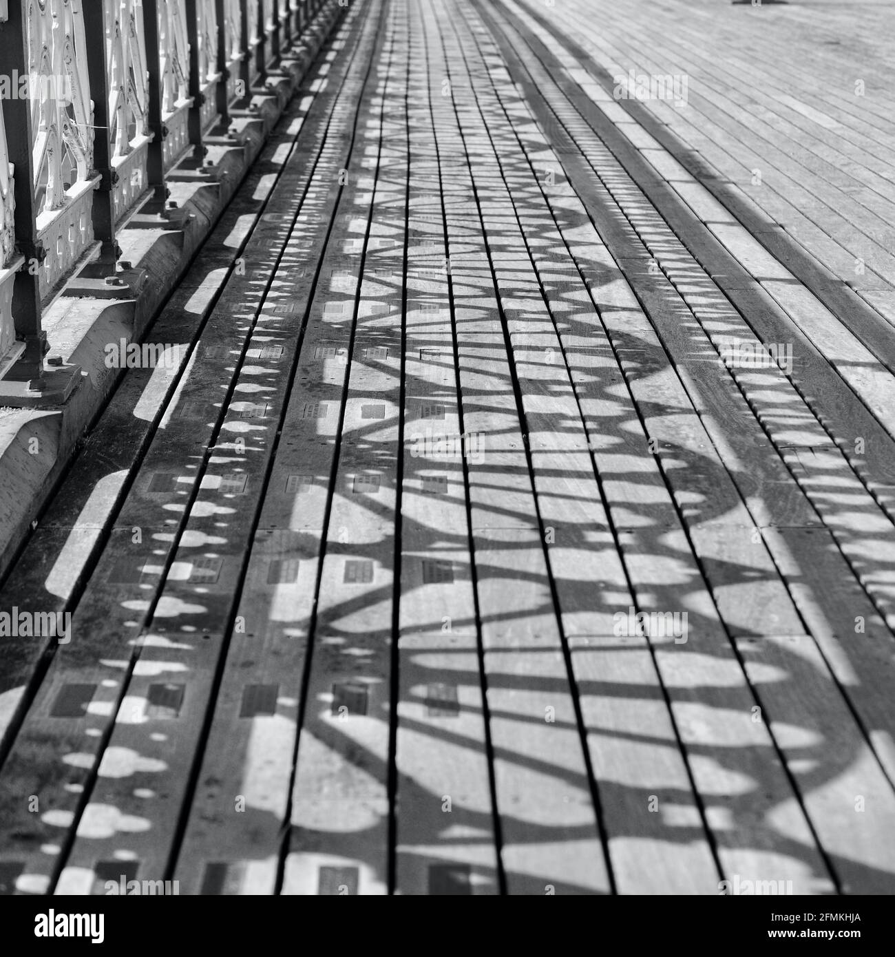 Monochrome photo old Victorian pier and promenade. The sunlight streams ...