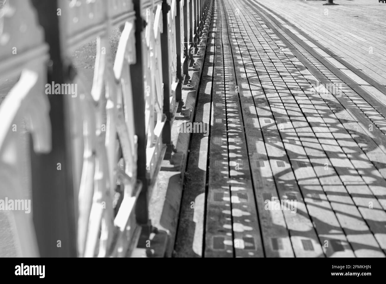 Monochrome photo old Victorian pier and promenade. The sunlight streams ...