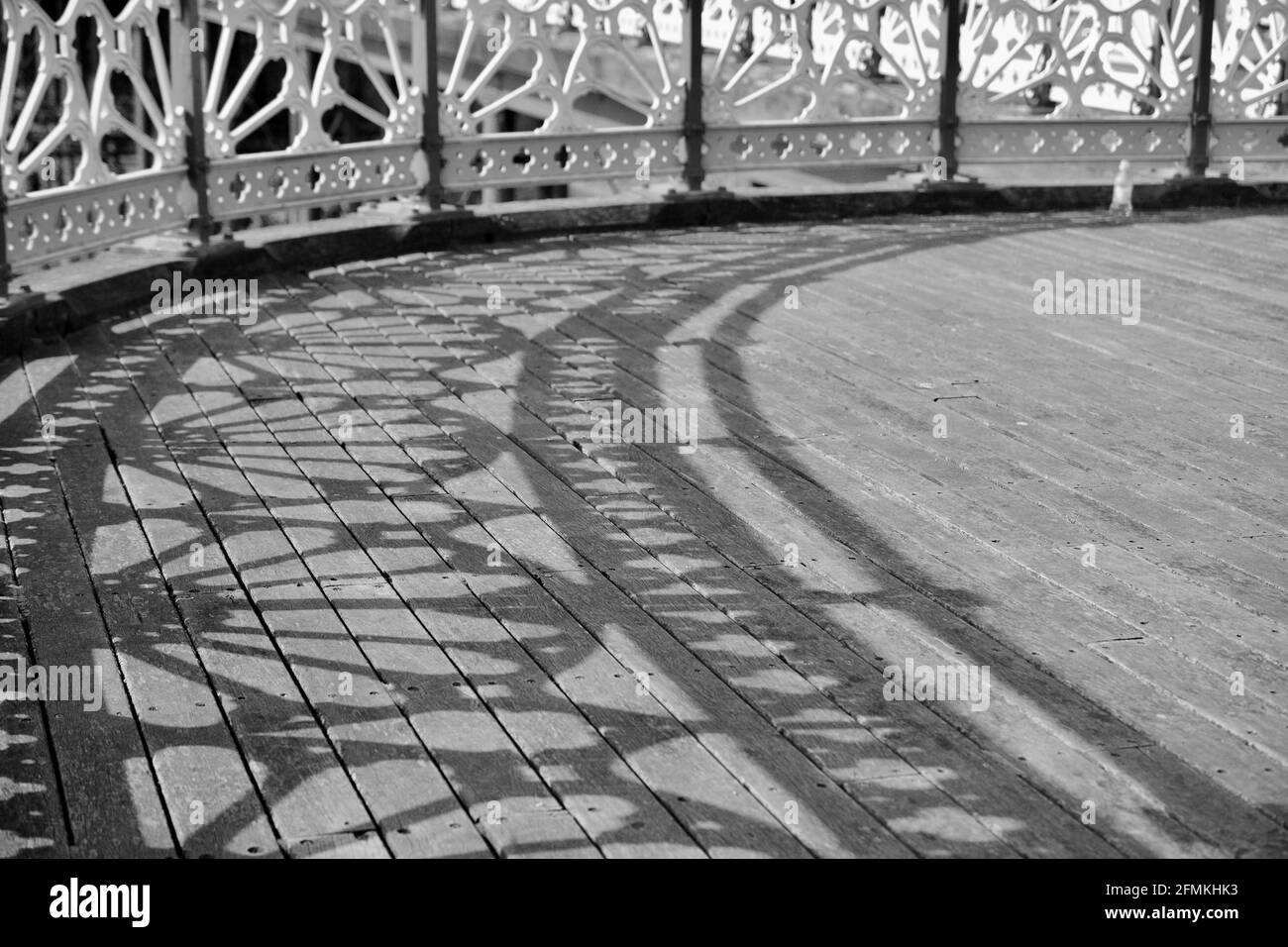 Monochrome photo old Victorian pier and promenade. The sunlight streams ...