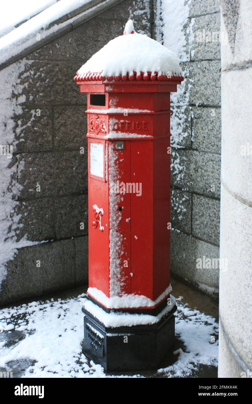 Snow settled on a traditional British red pillar box (post box ...