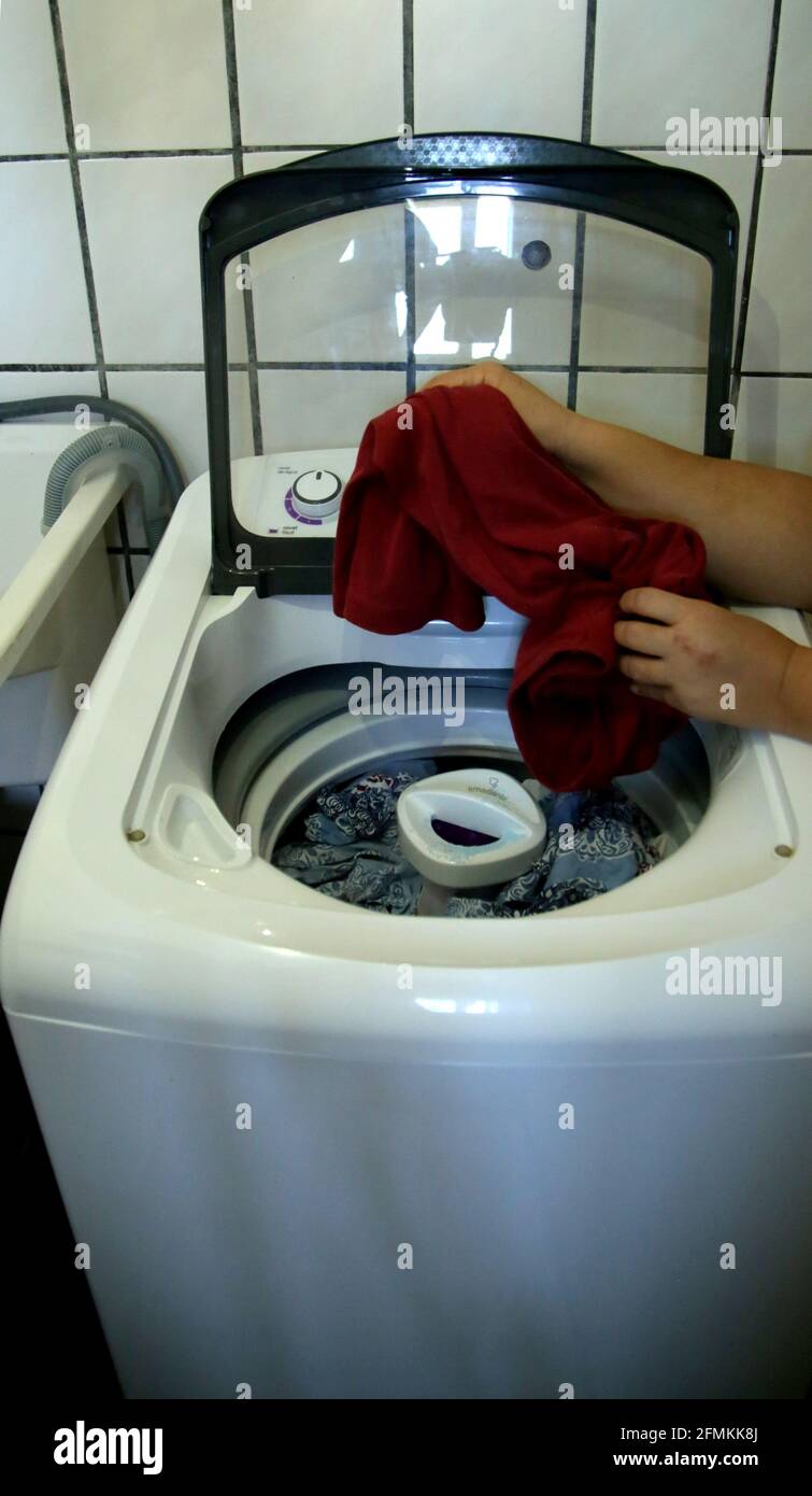 salvador, bahia, brazil - may 24, 2020: hand is seen putting washing ...