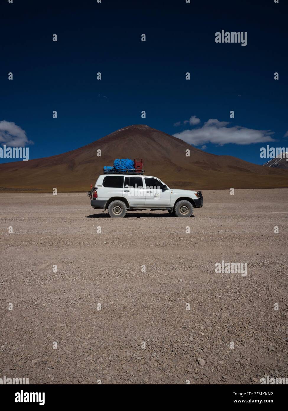 Jeep SUV car transportation vehicle in front of cone shaped volcano ...