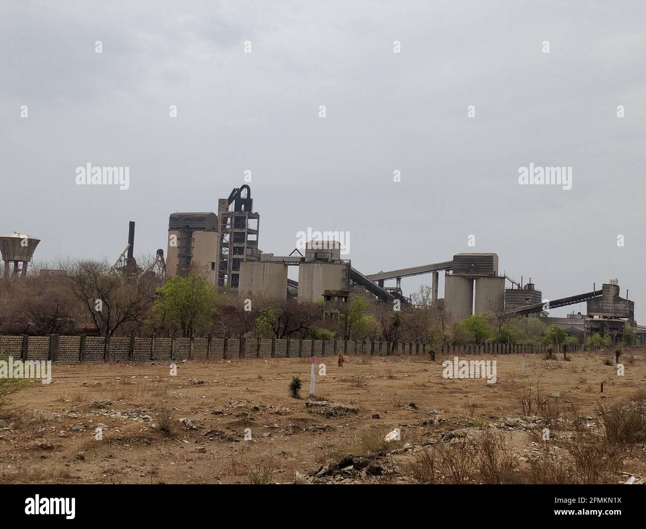 Landscape of an abandoned factory in a field under a cloudy sky in ...