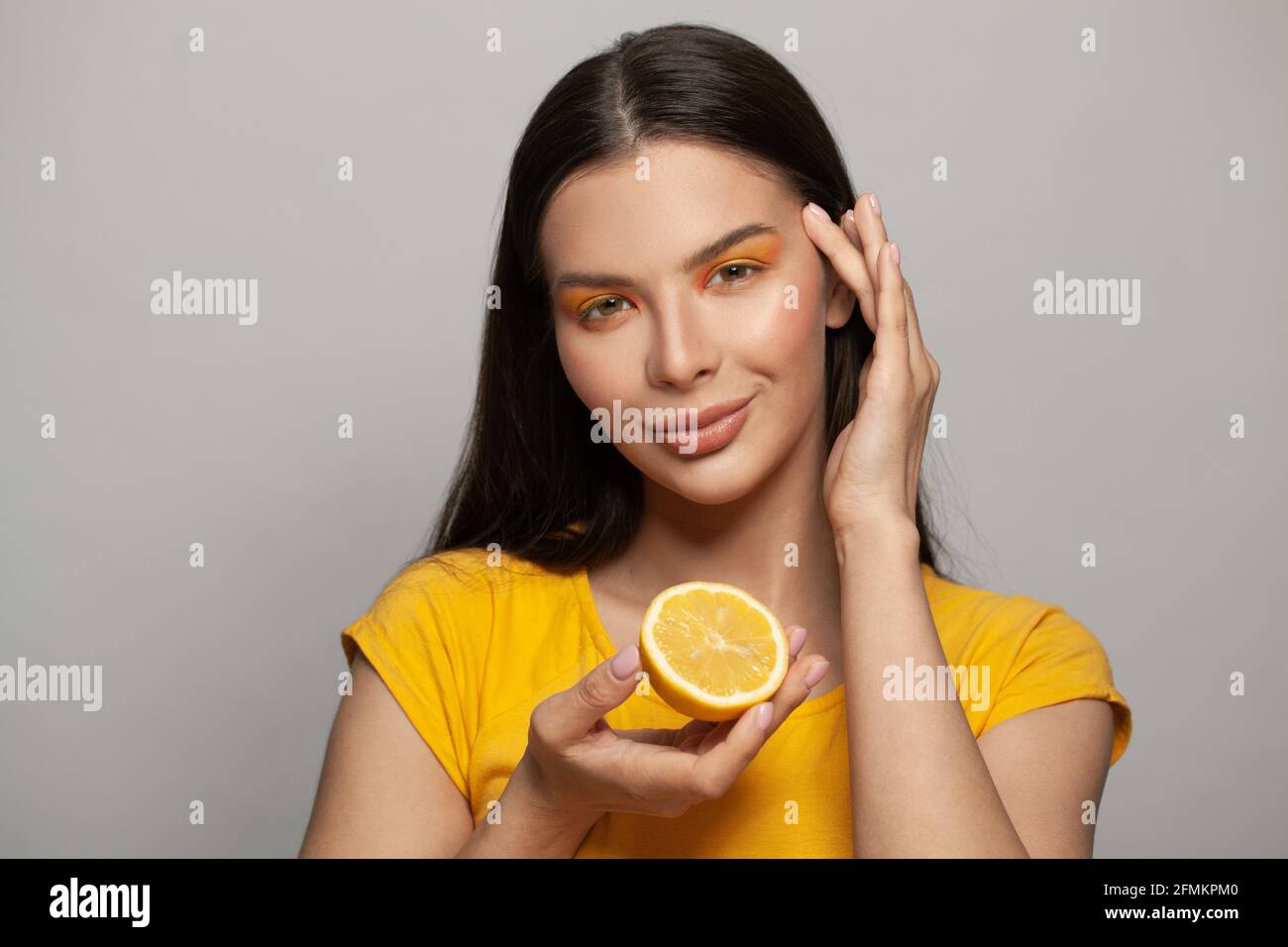Beautiful woman with healthy clear skin holding yellow lemon fruits on ...