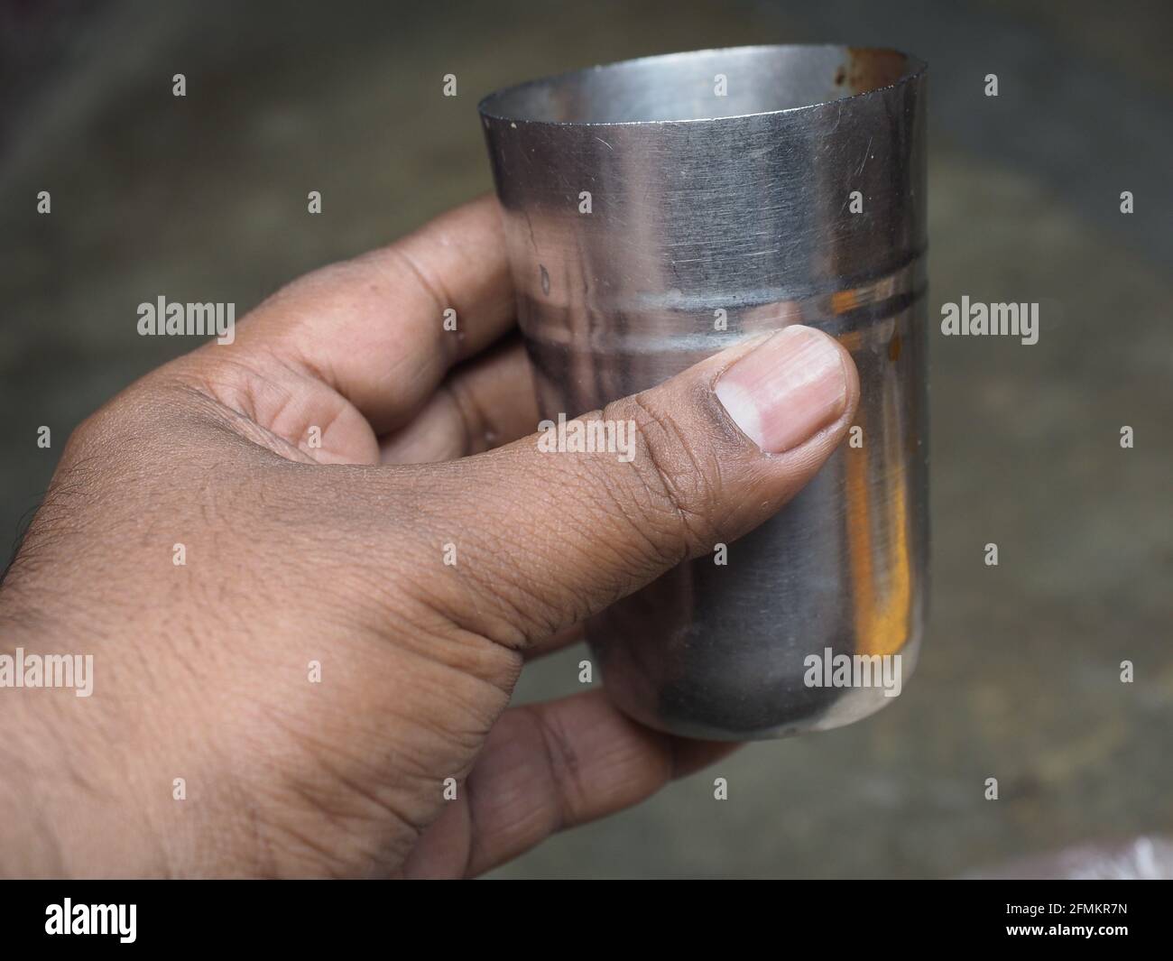 A man holding a steel glass in old background Stock Photo - Alamy