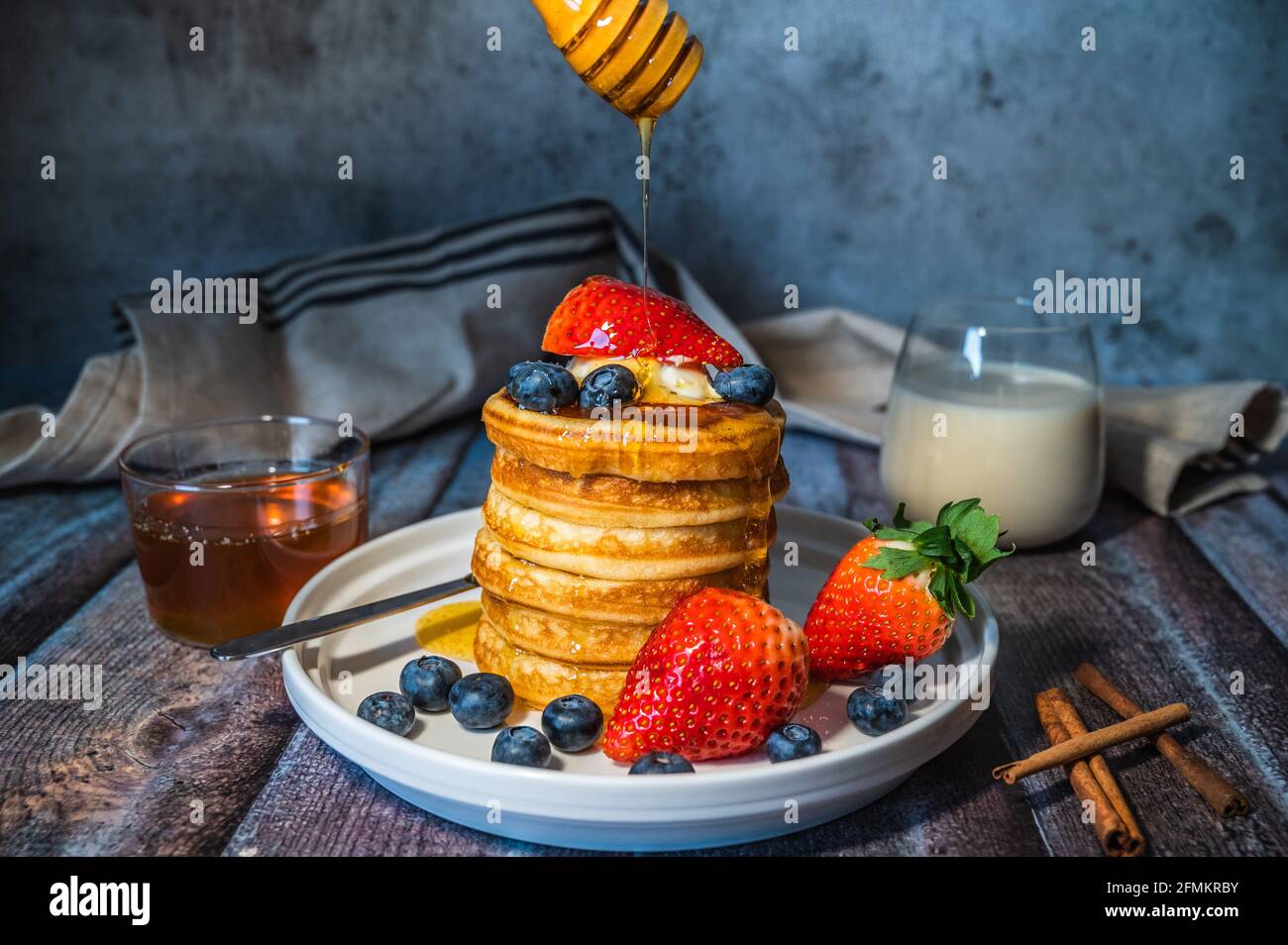A stack of healthy pancakes with pouring maple syrup from stick, fresh ...