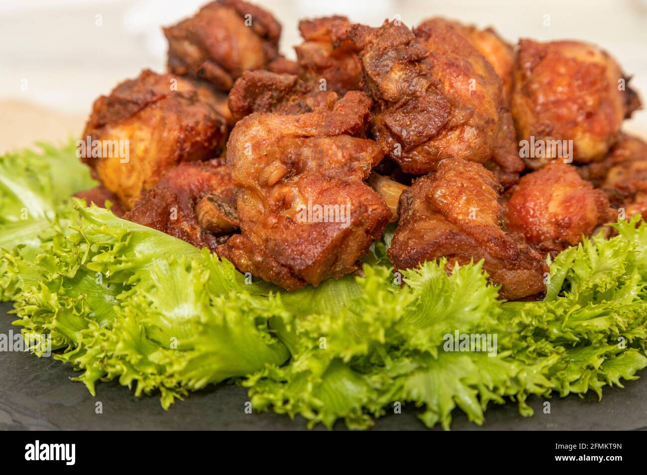 Portion of fried chicken on black stone plate Stock Photo - Alamy