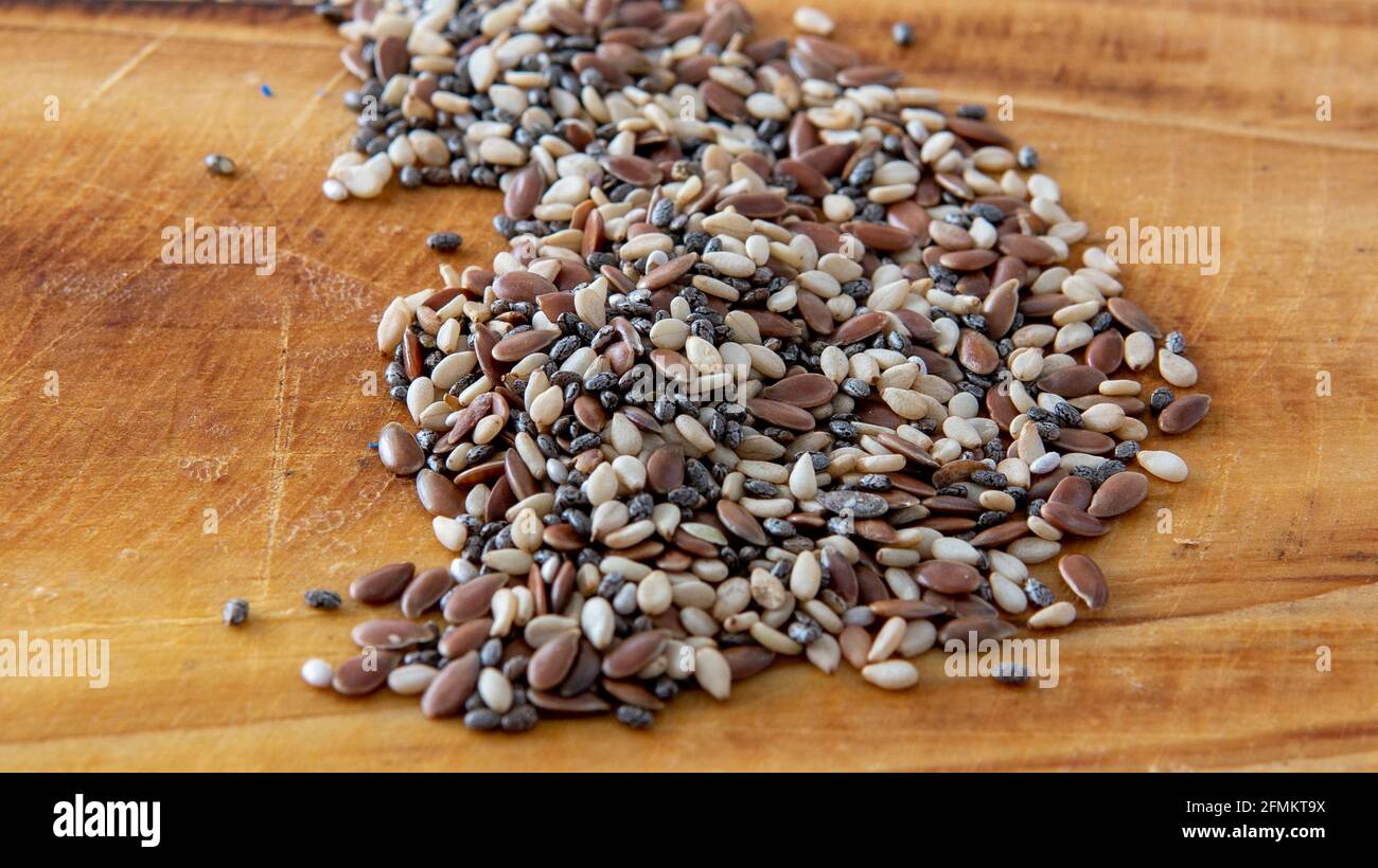 Close view of chia, flax and sesame seeds mix over a white background ...