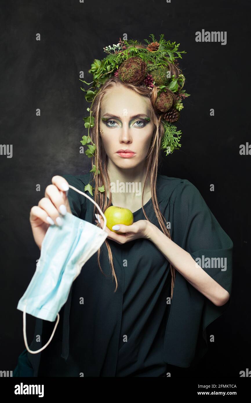 Woman giving up used medical face mask. Environment protection concept ...