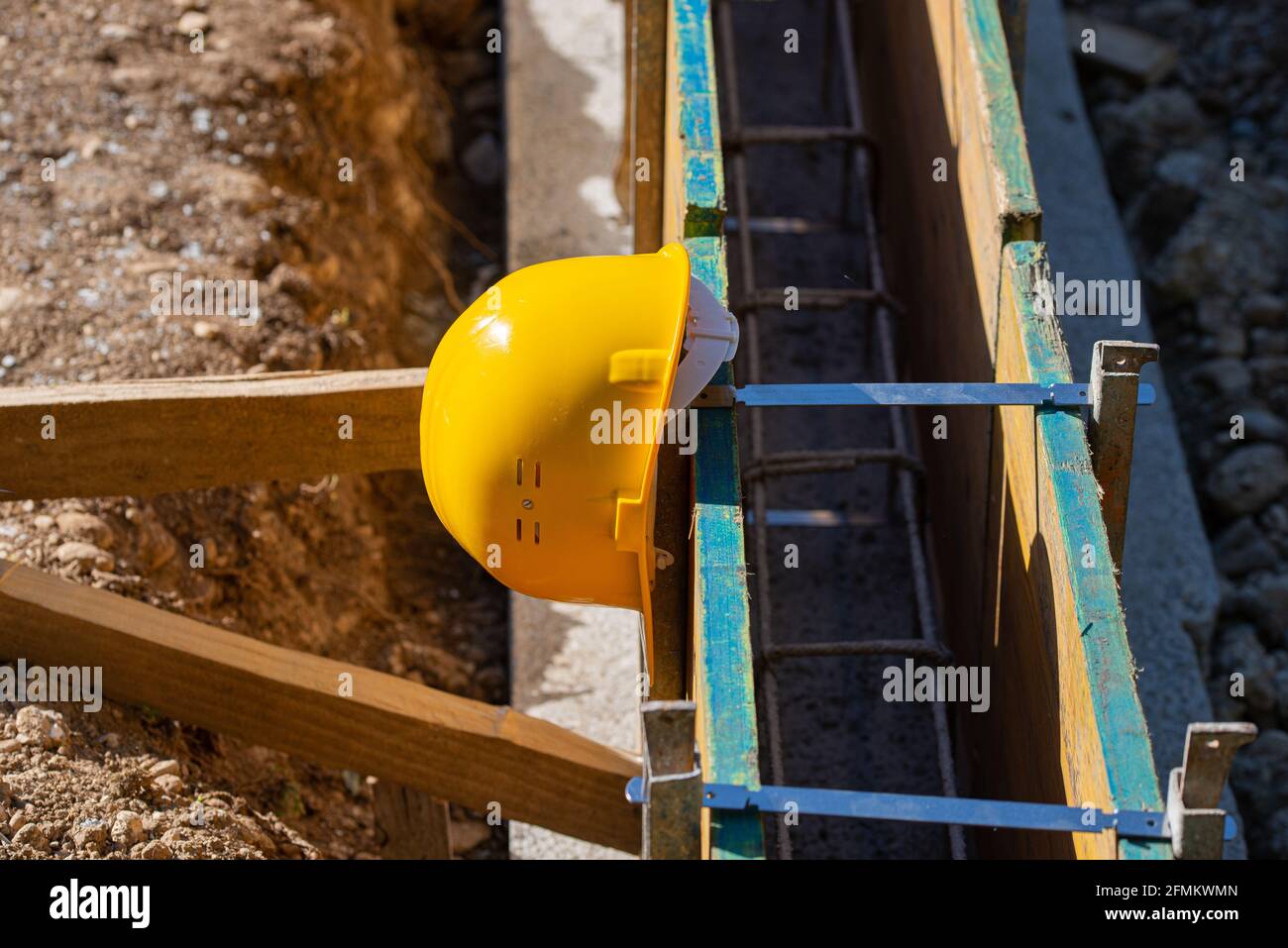 Yellow protective hardhat resting on a framework of wooden panels in a ...