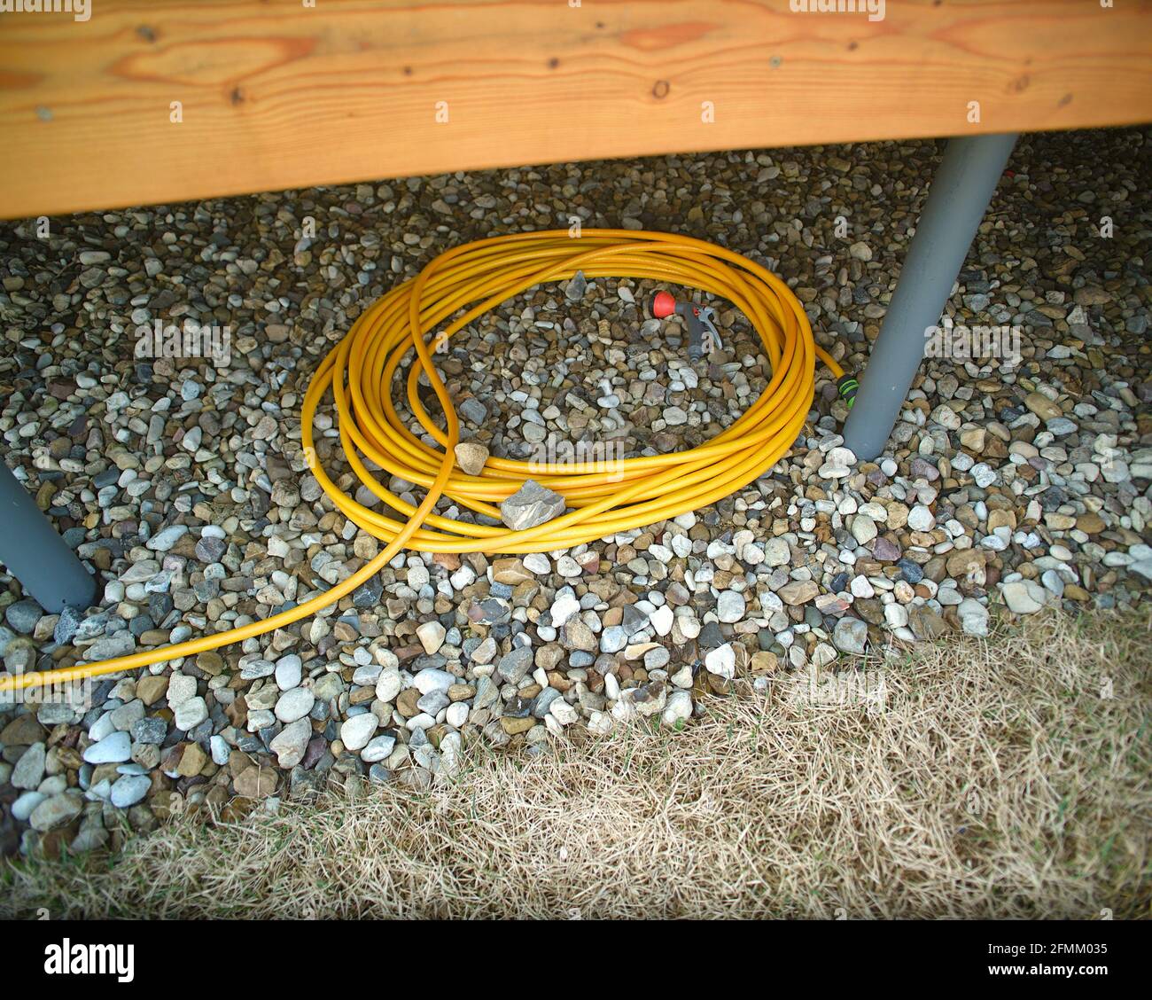 Garden hose reel pipe on the ground under porch Stock Photo - Alamy