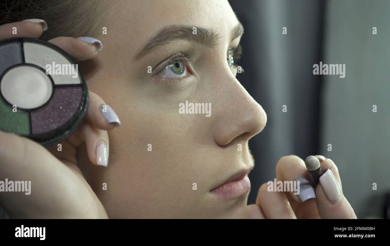 Photo of master applying eyeshadows on eyes Stock Photo - Alamy