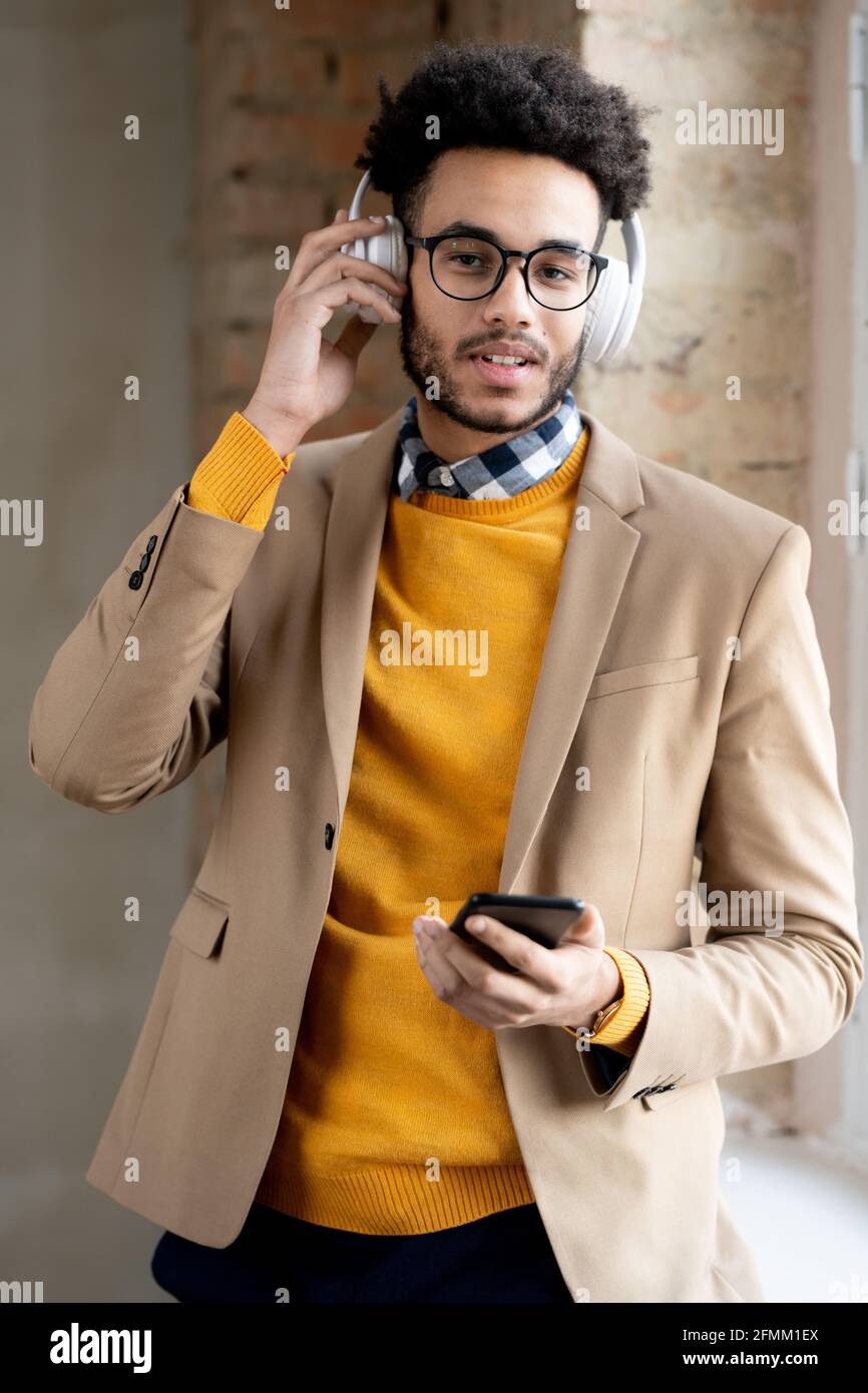 Portrait of positive handsome young mixed race man using smartphone and ... Portrait of positive handsome young mixed race man using smartphone and ...
