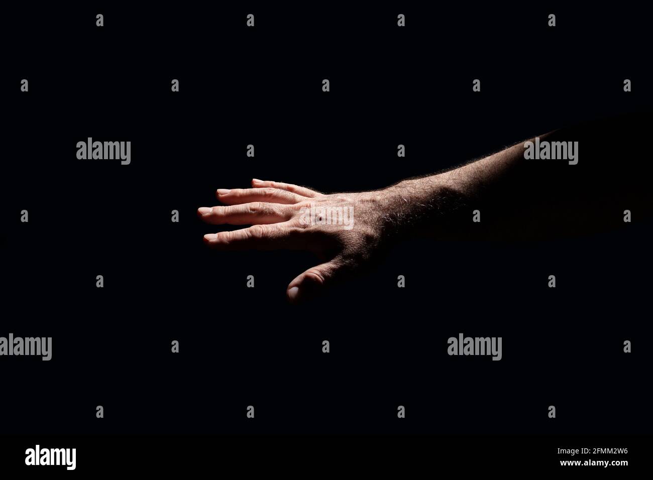 Light shining on a male hand in total darkness Stock Photo - Alamy