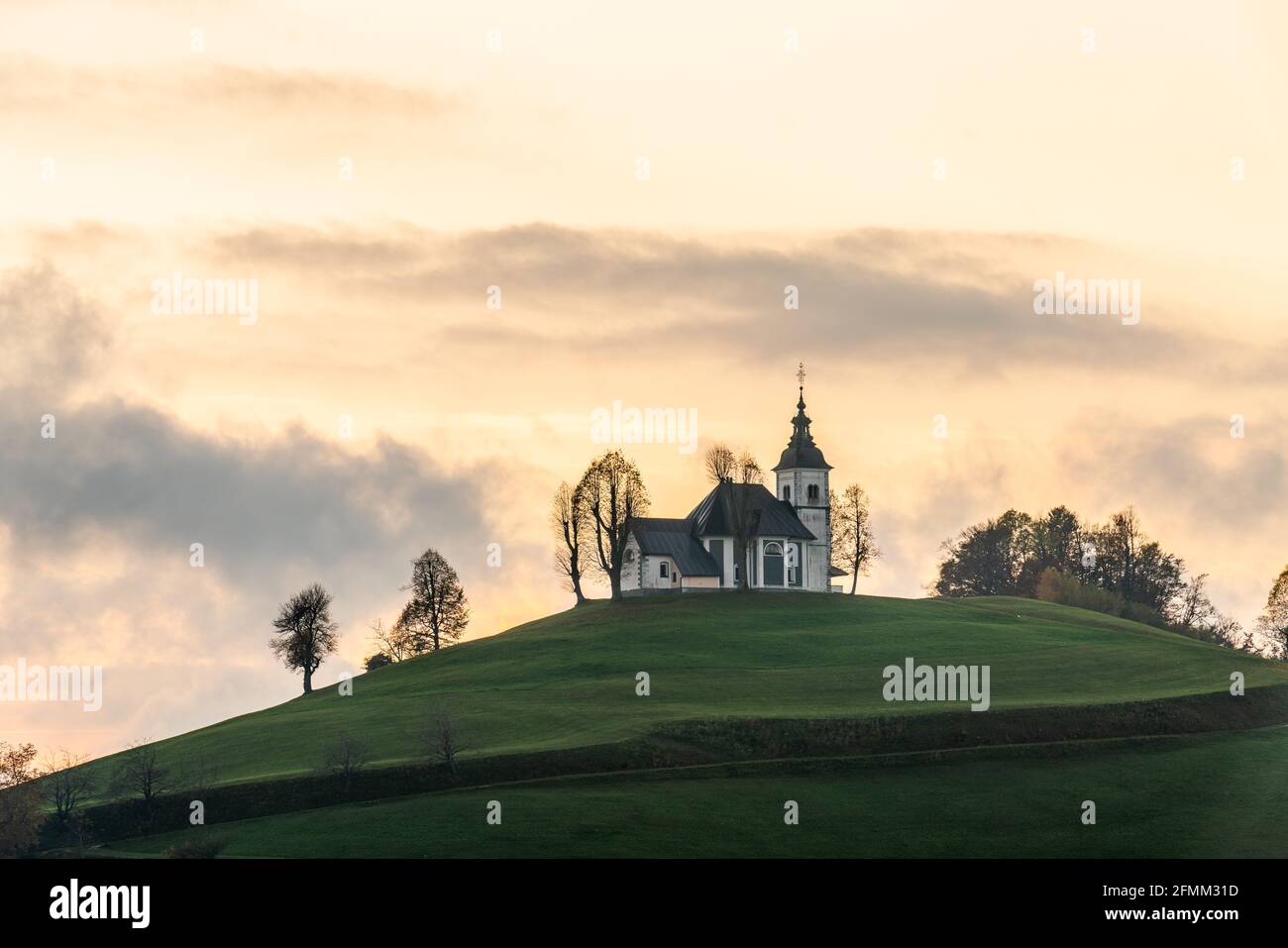 A colorful sunset in cloudy weather. View of the church Sv Sobota ...