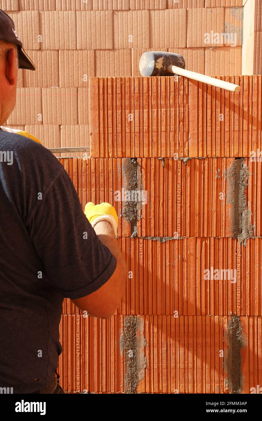 Construction worker (bricklayer) works on the construction site Stock ...