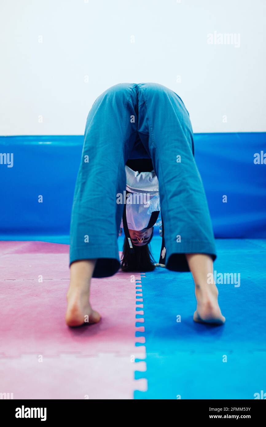Young woman stretching in a dojo wearing taekwondo dobok Stock Photo ...