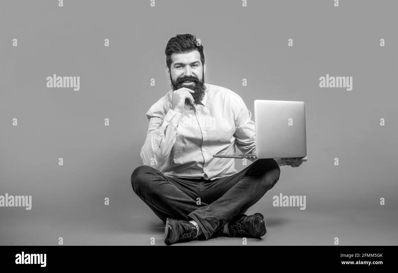 Young businessman using his laptop, pc. Happy young man sitting on the ...